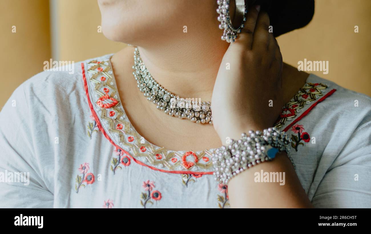 A cheerful Indian woman wearing a colorful sari and traditional jewelry ...