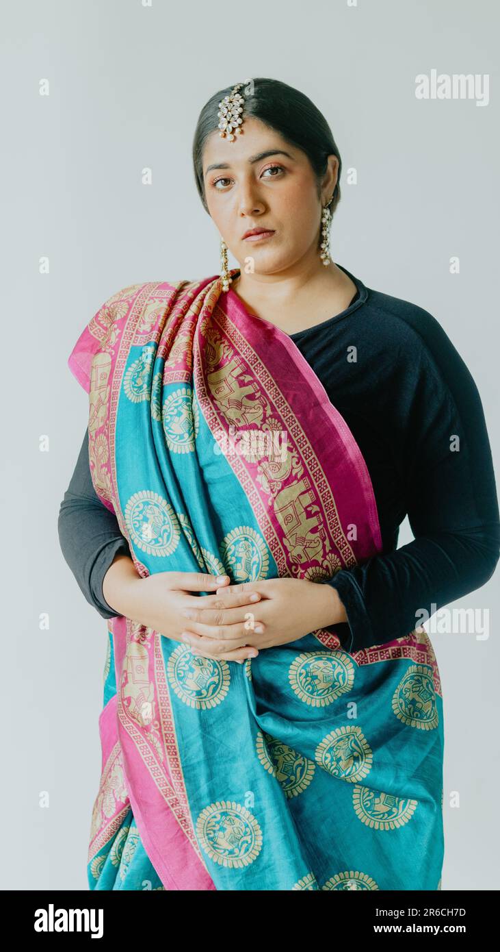 A young woman stands confidently wearing traditional clothing ...