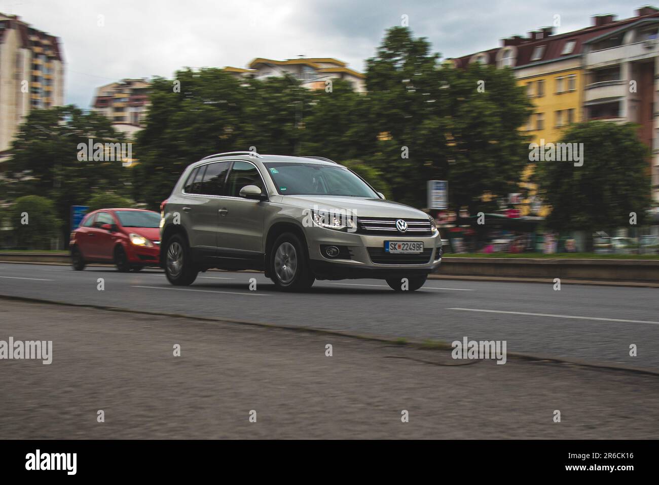 Grey Volkswagen car driving fast/speeding between other cars on a road ...