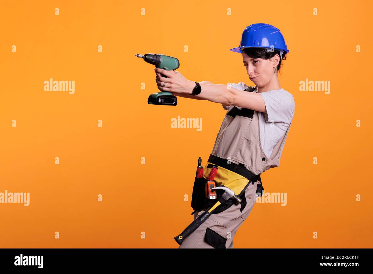 Professional builder woman holding cordless power drill gun and having ...