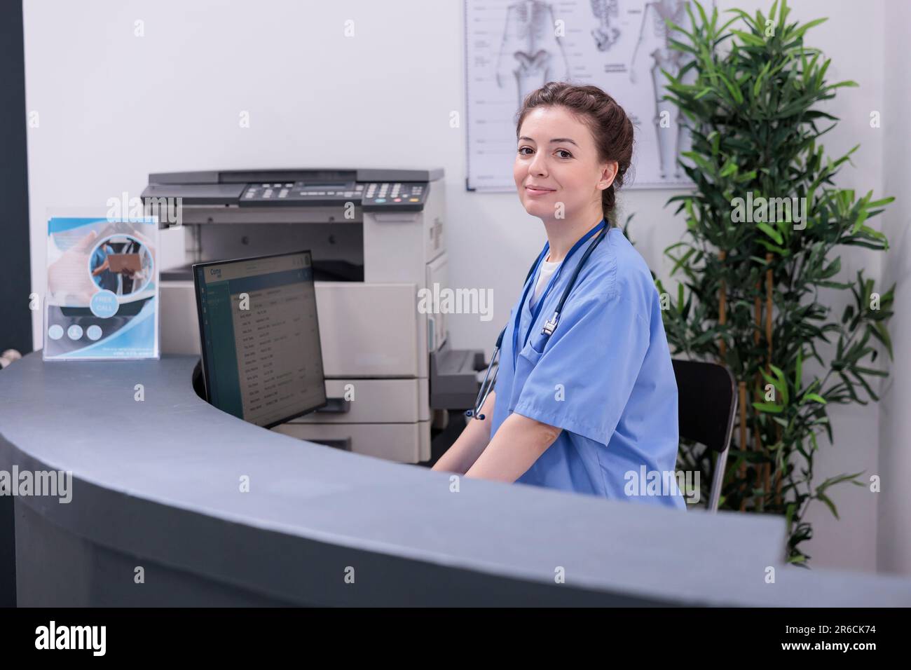 Smiling assistant typing medical expertise on computer while working at ...