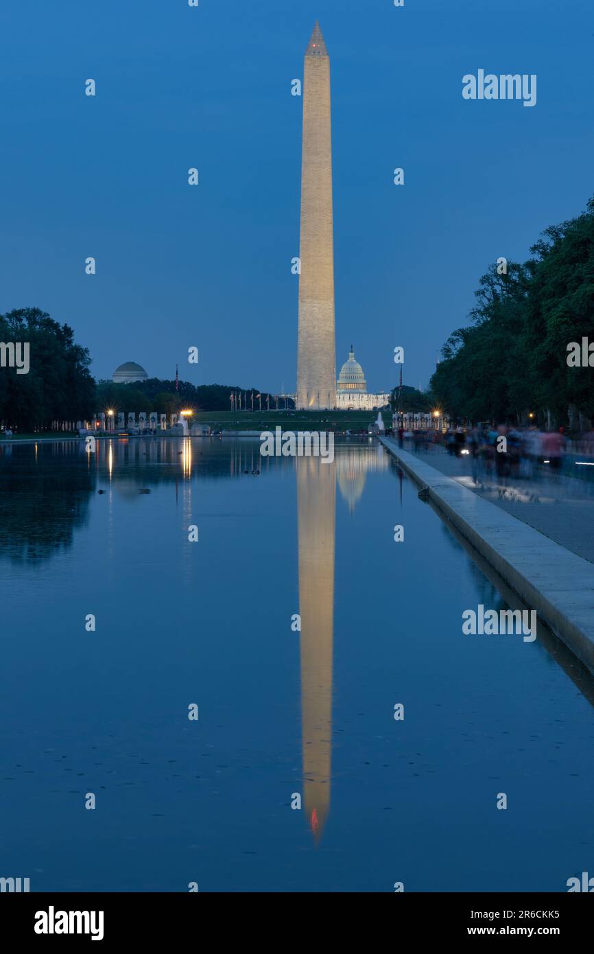 Washington Monument lit at night with the US Capitol building in the ...