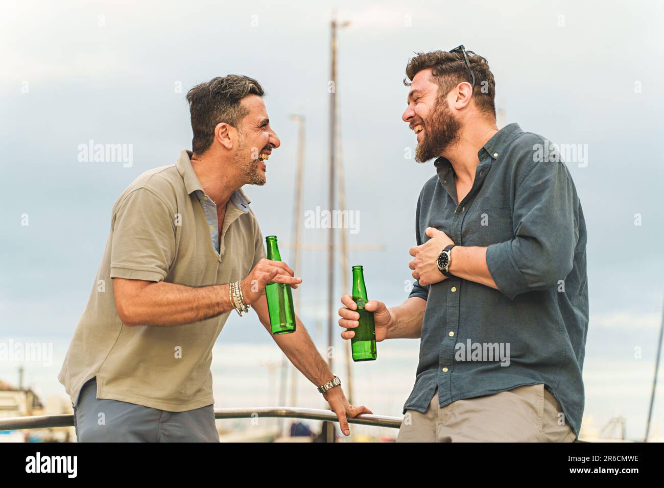 Two caucasian friends in their forties laughing heartily on the deck of ...