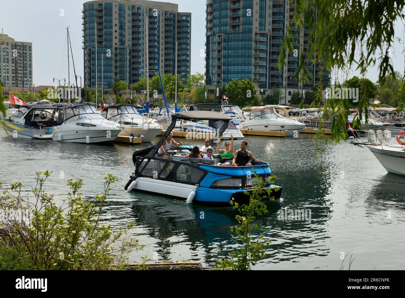 Waving smiling boaters coming in from Kempenfelt Bay to dock at Barrie ...