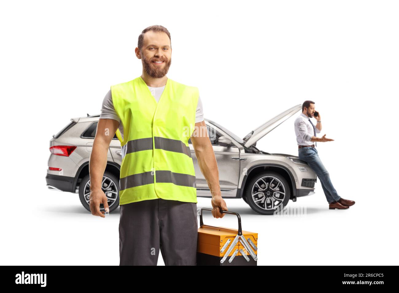 Road assistance worker in a reflective vest standing in front of a car ...