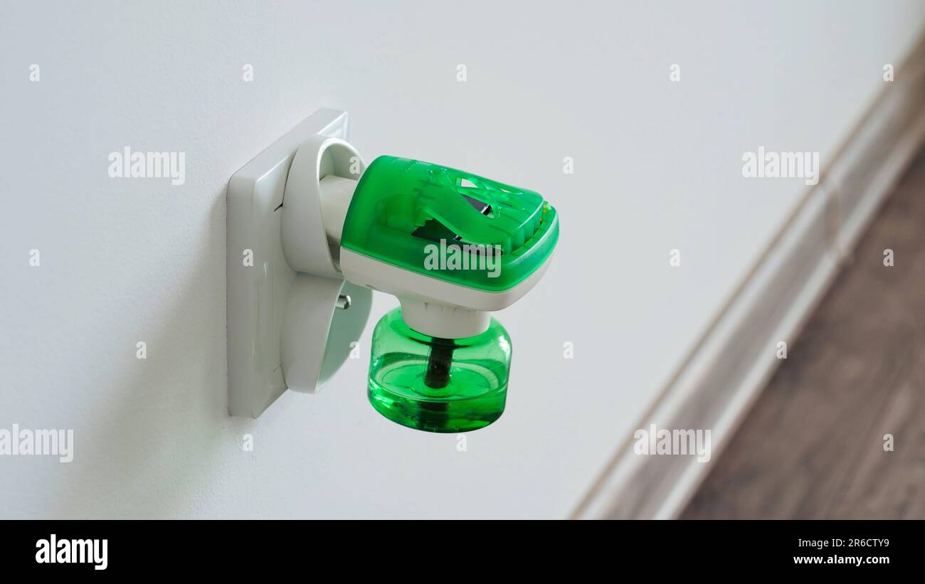 Close-up an electric green fumigator in socket protect against insect ...
