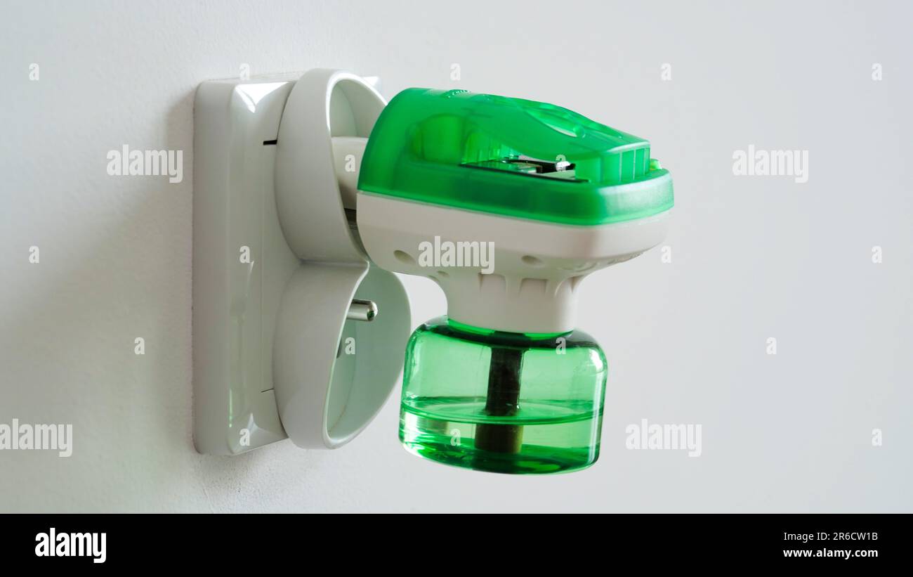 Close-up an electric green fumigator in socket protect against insect ...