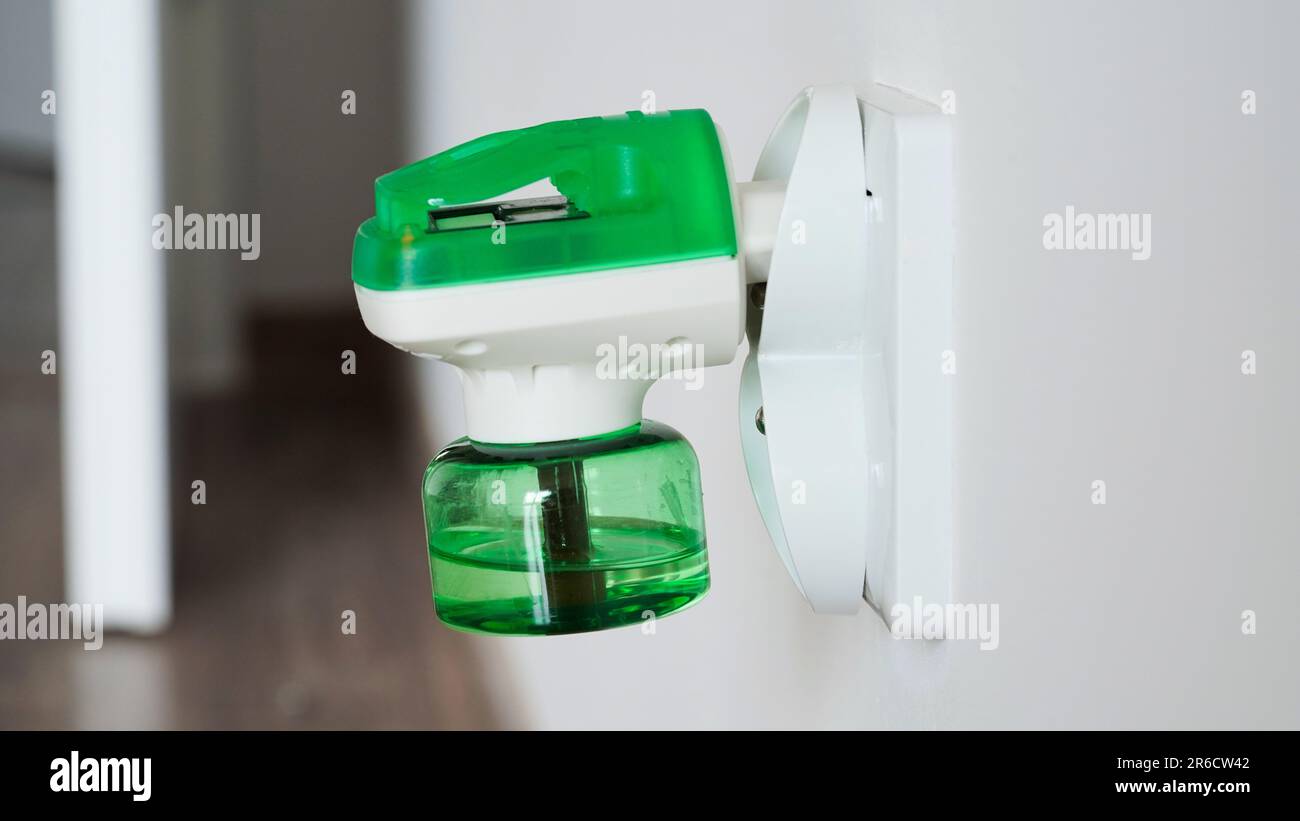 Close-up an electric green fumigator in socket protect against insect ...