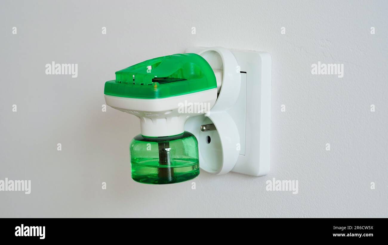 Close-up an electric green fumigator in socket protect against insect ...