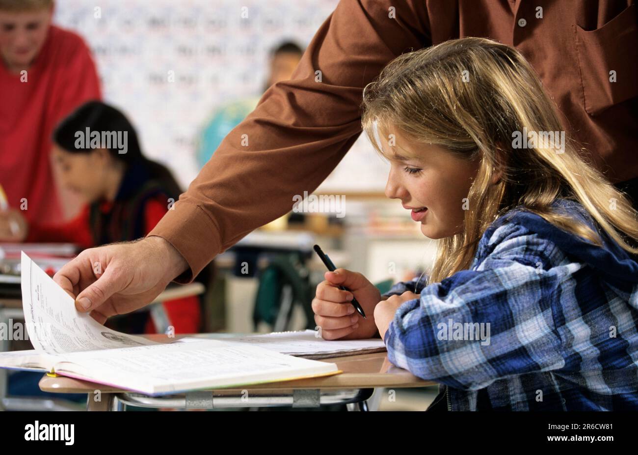 pupil being helped by her teacher in a middle school classroom Stock ...