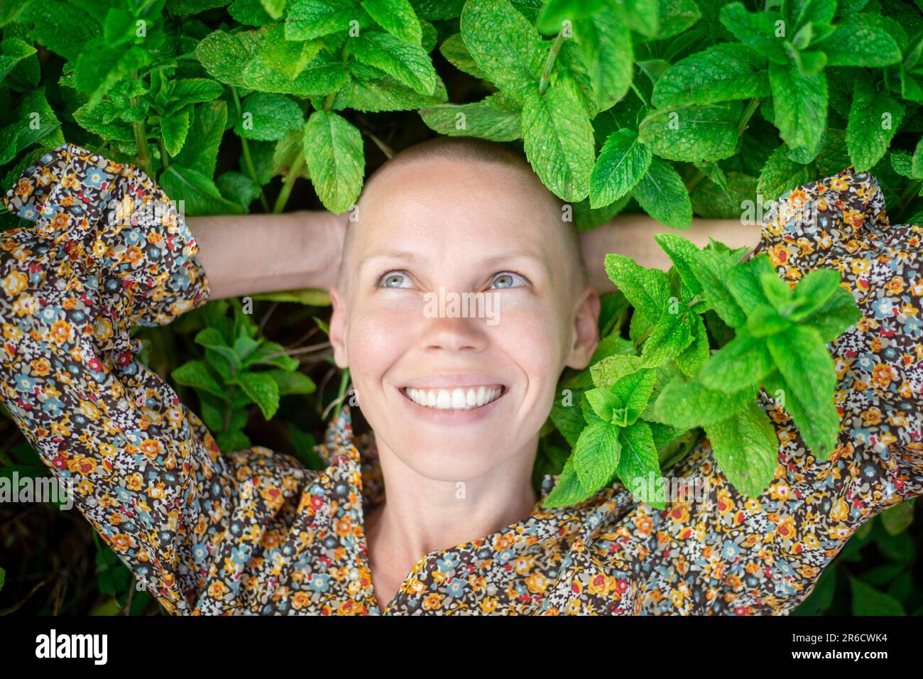Happy contented woman smiling in mint leaves. Aromatherapy, freshness ...