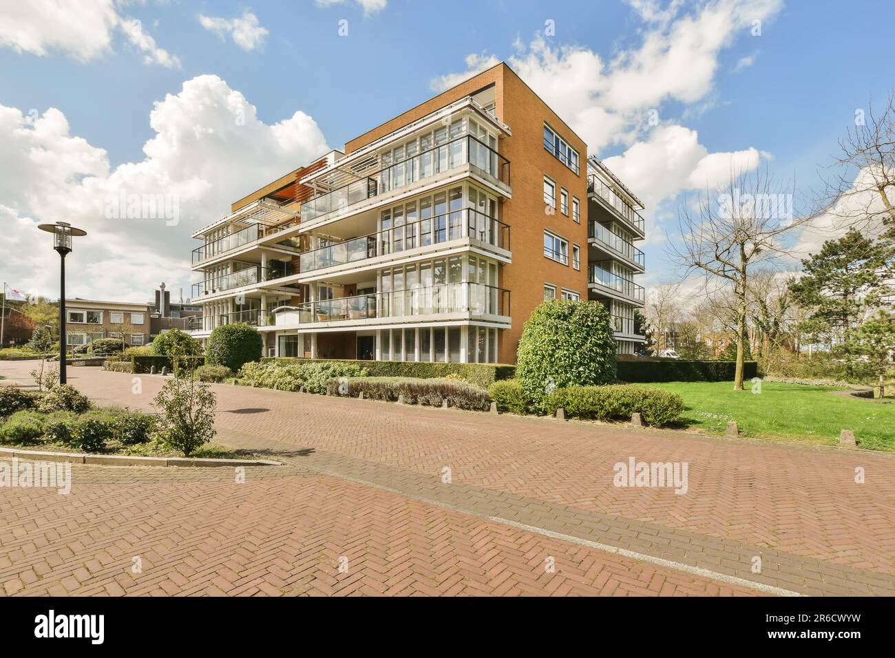 an apartment complex in the suburbs, with brick pavings and green grass ...