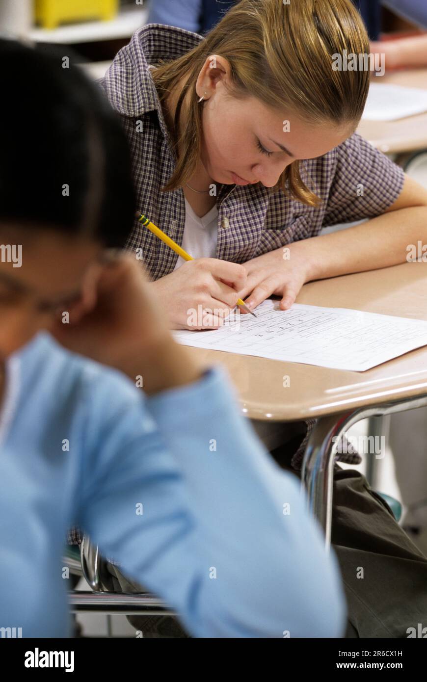 female pupil at her desk being tested Stock Photo - Alamy
