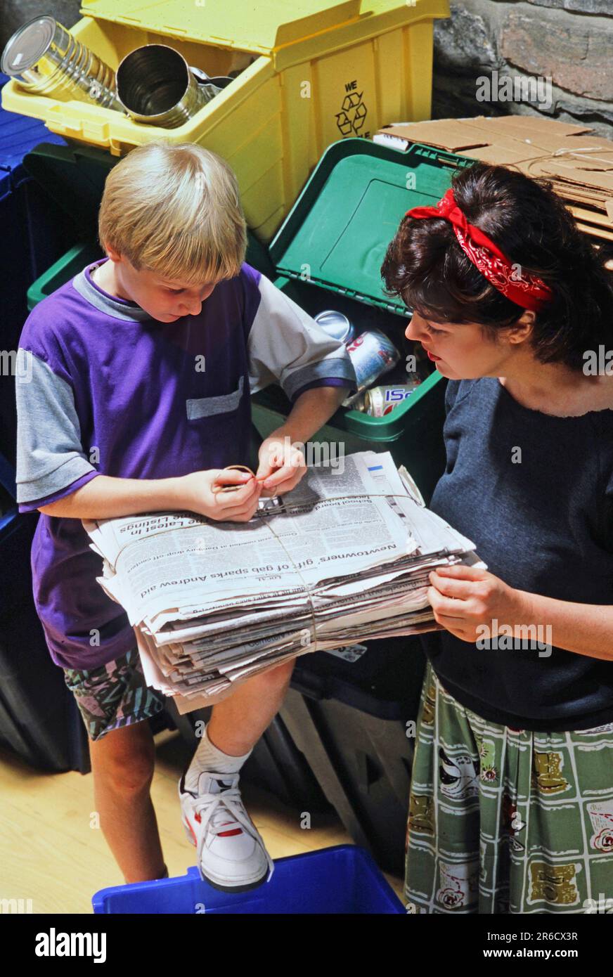 Mother and son sorting recyclables and placing them into variety of ...
