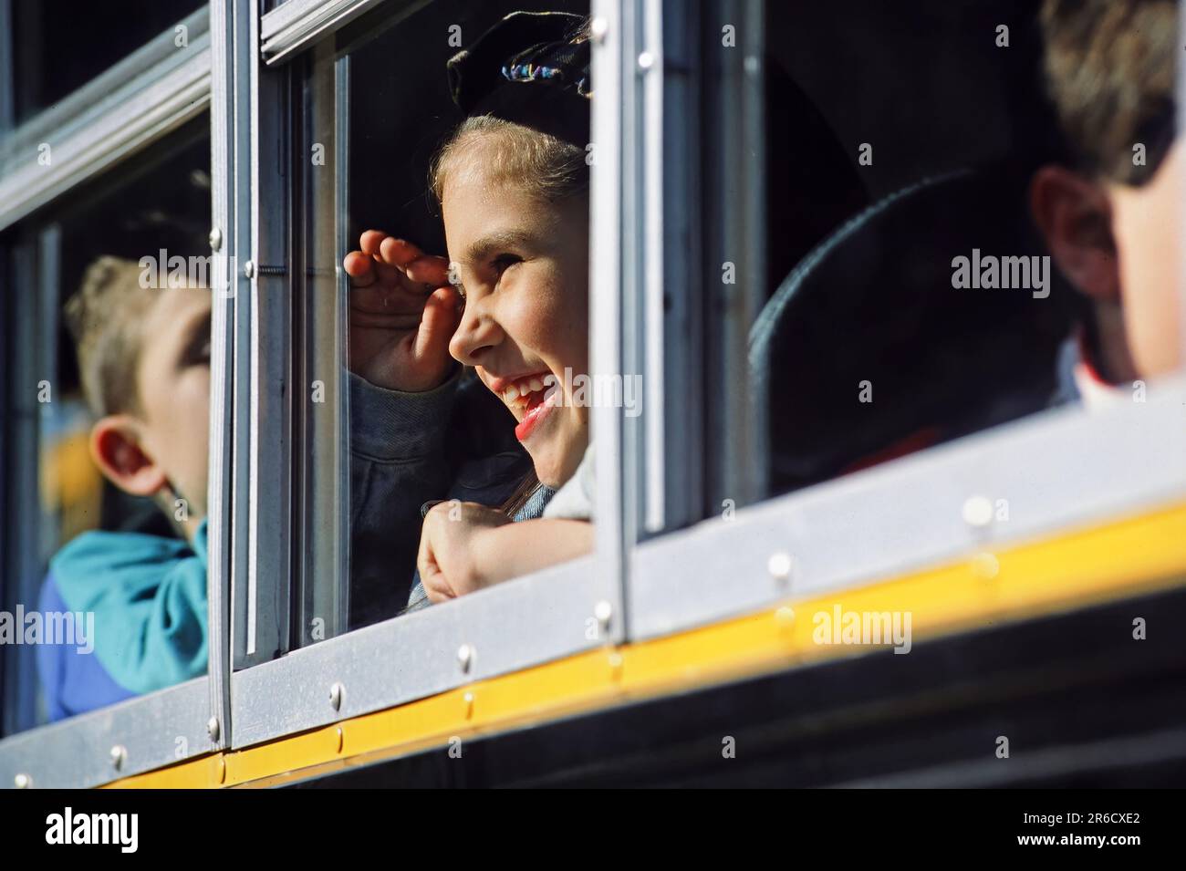 Cook Kasian student looking out of a school bus window and waving ...
