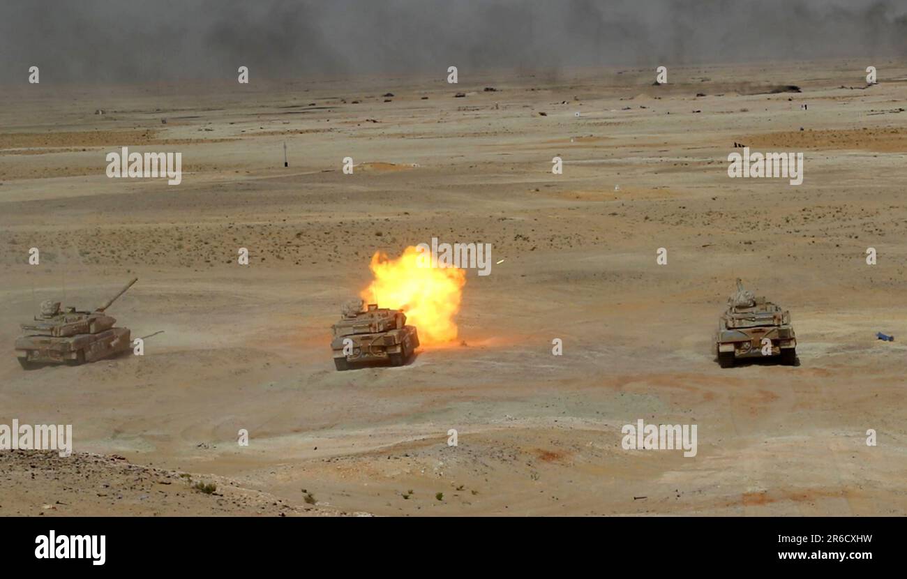 A Qatari tank crew sends a round into a target area during a combined ...