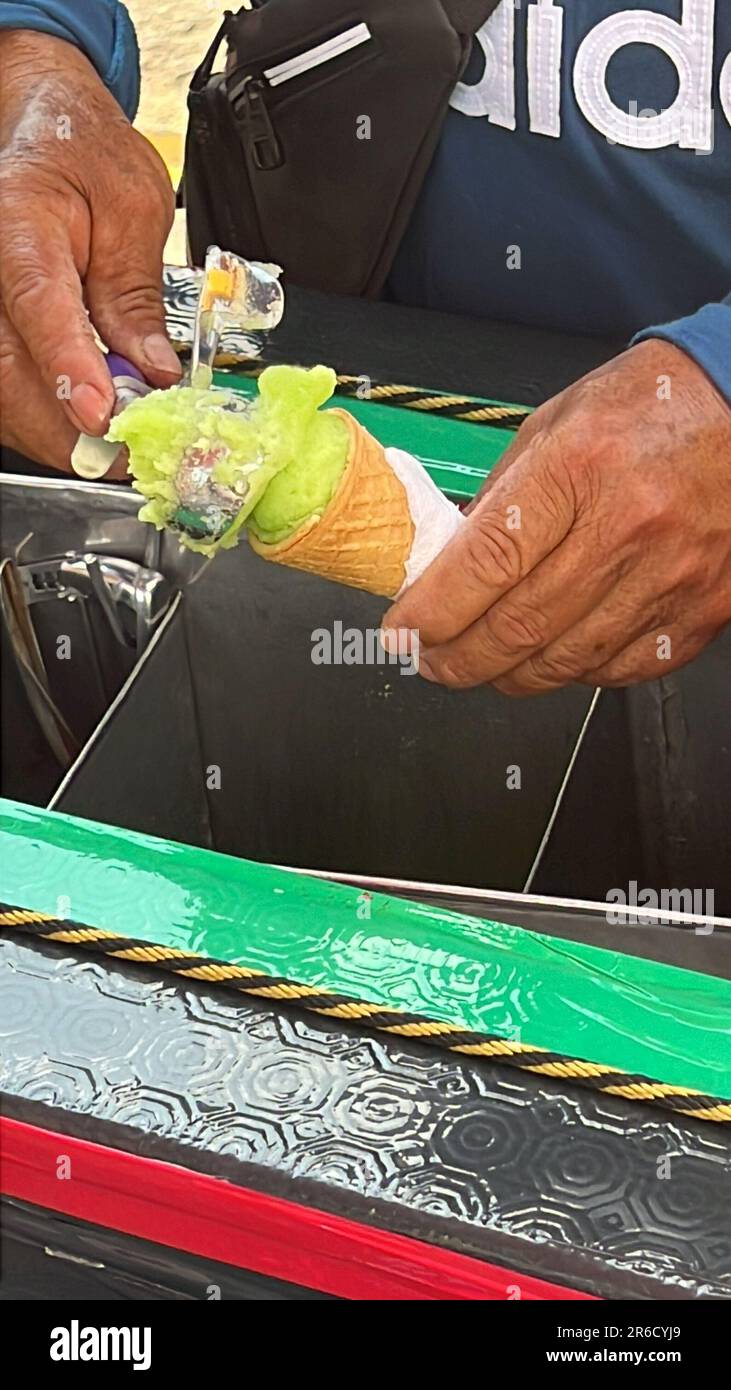 Man scooping ice cream into a cone with an ice cream scoop Stock Photo ...