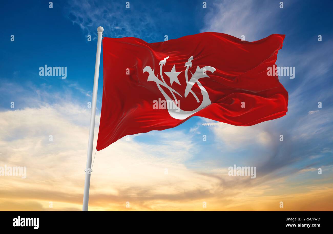 official flag of Kelantan Malaysia at cloudy sky background on sunset, panoramic view. Malaysian ...