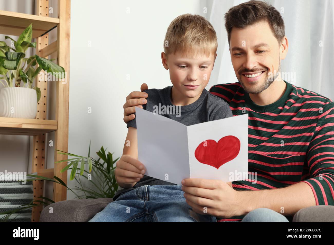 Happy man receiving greeting card from his son at home Stock Photo - Alamy
