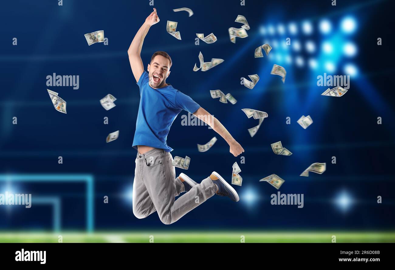 Sports betting. Happy man jumping under money shower. Stadium on ...