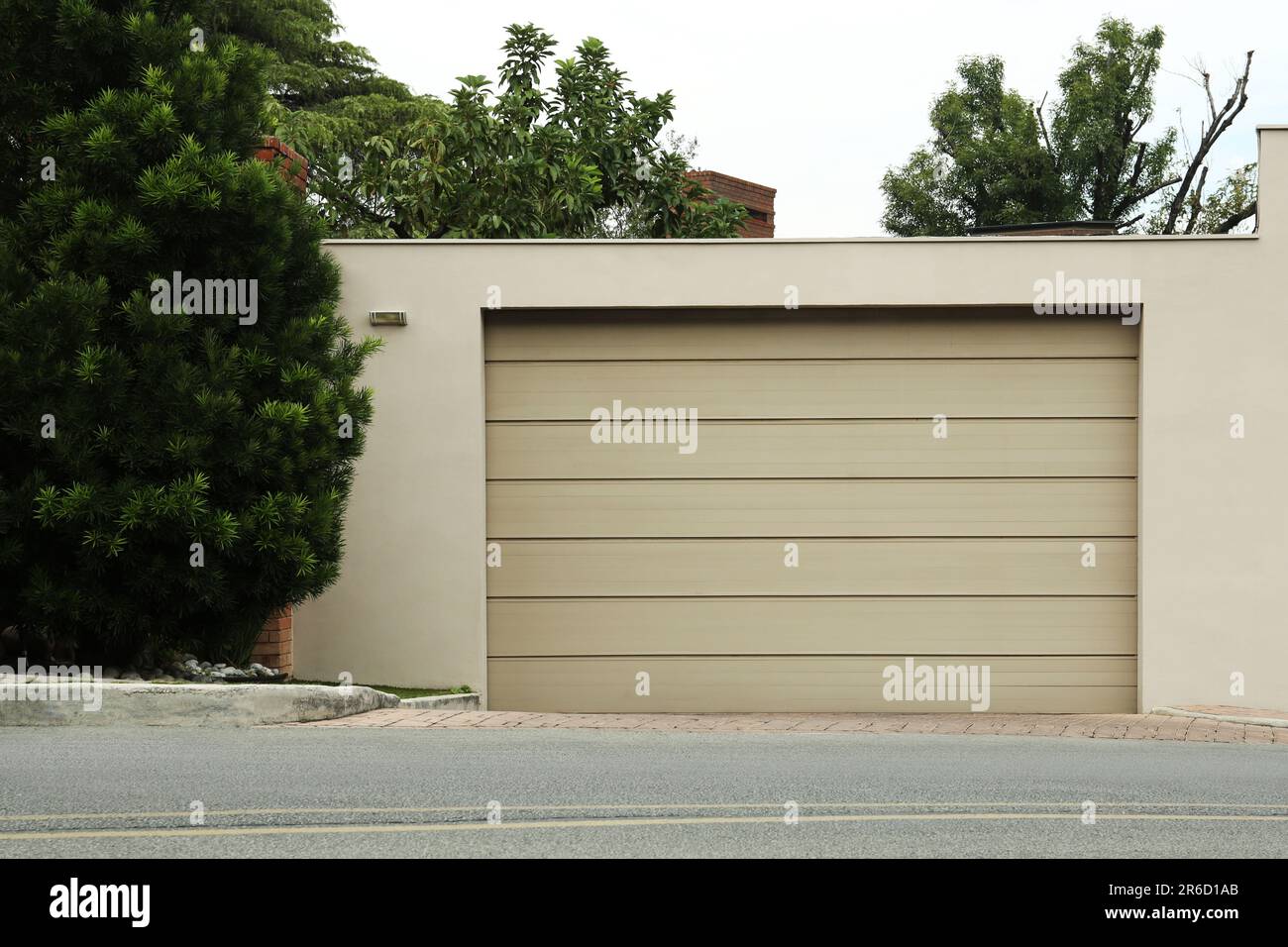 Beige garage with closed sectional door. Exterior design Stock Photo ...