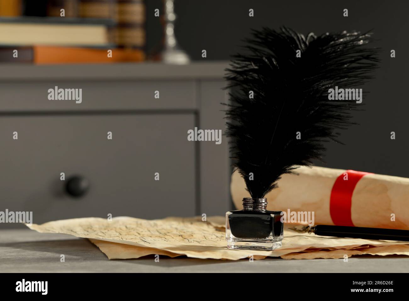 Inkwell with feather, fountain pen and vintage parchment on grey ...