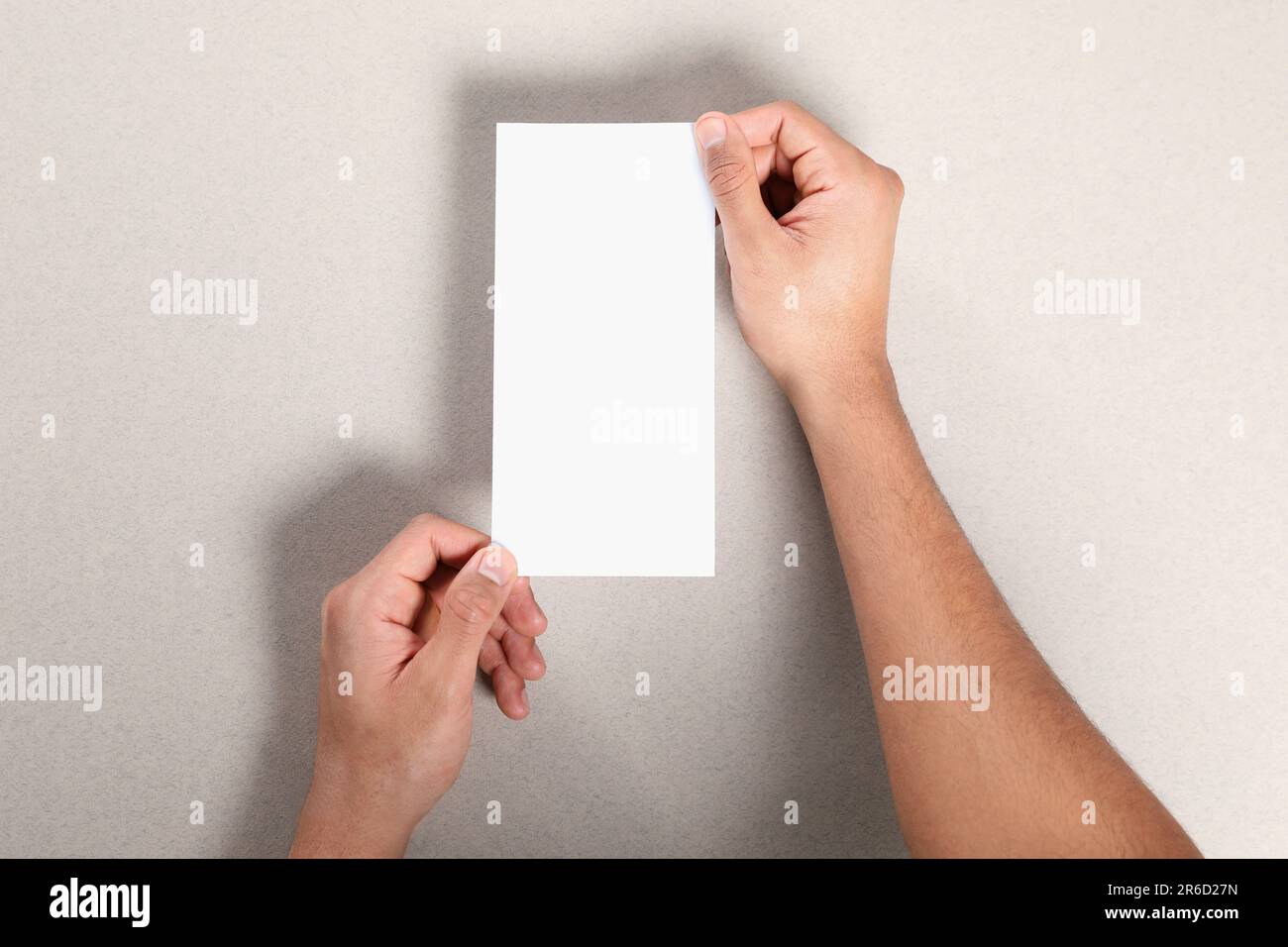 Man holding flyer on grey background, closeup. Mockup for design Stock ...