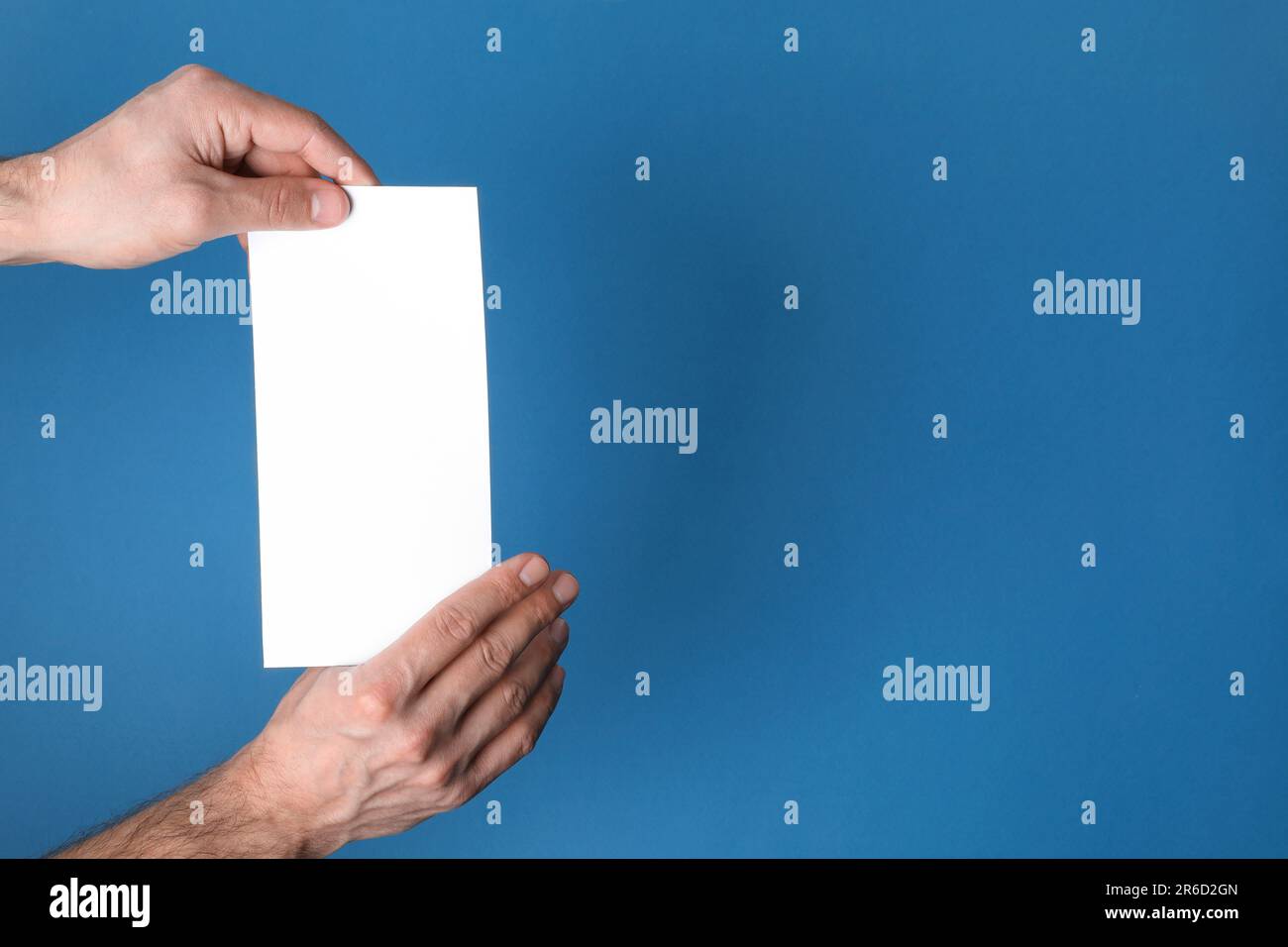 Man holding flyer on blue background, closeup. Mockup for design Stock ...