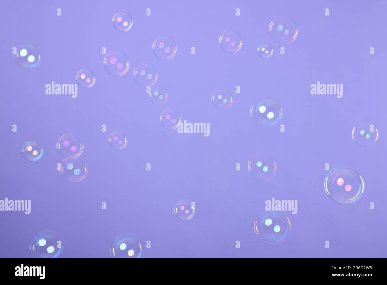 Many beautiful soap bubbles on violet background Stock Photo - Alamy