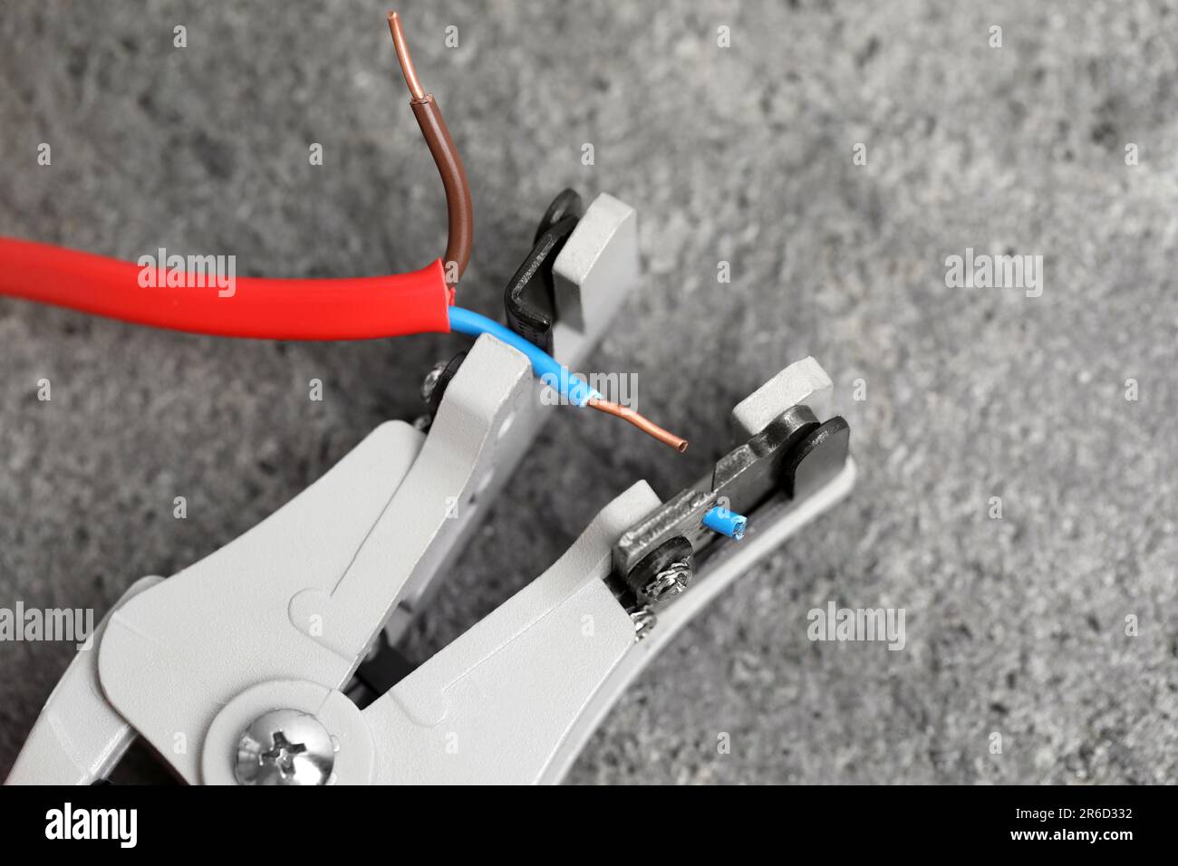 Cutters and stripped wire on light gray textured table, above view ...