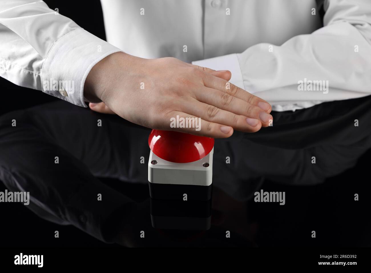 Man pressing red button of nuclear weapon on black background, closeup ...