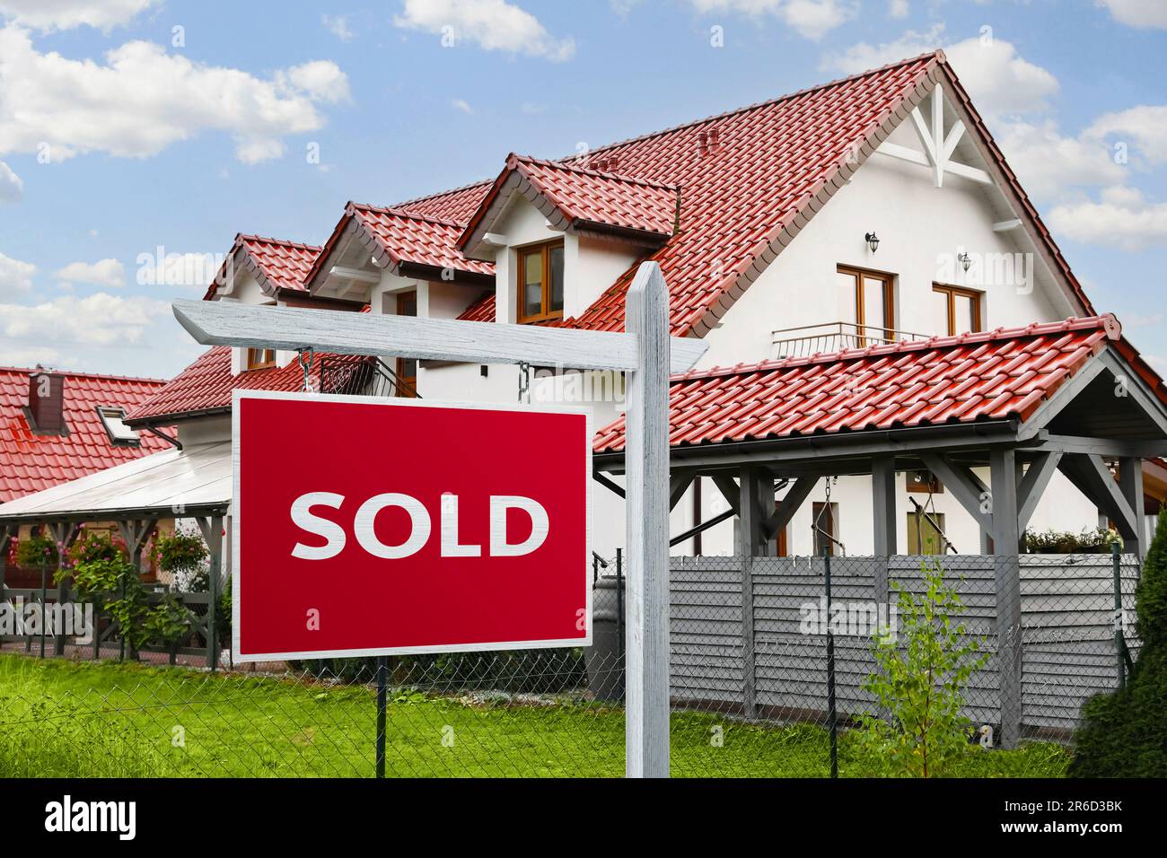 Red Sold sign near beautiful house outdoors Stock Photo - Alamy