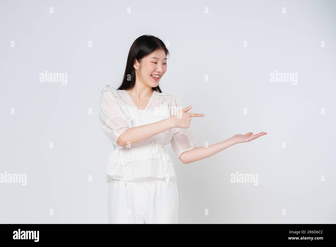 Happy young woman presenting or showing open hand palm with copy space ...