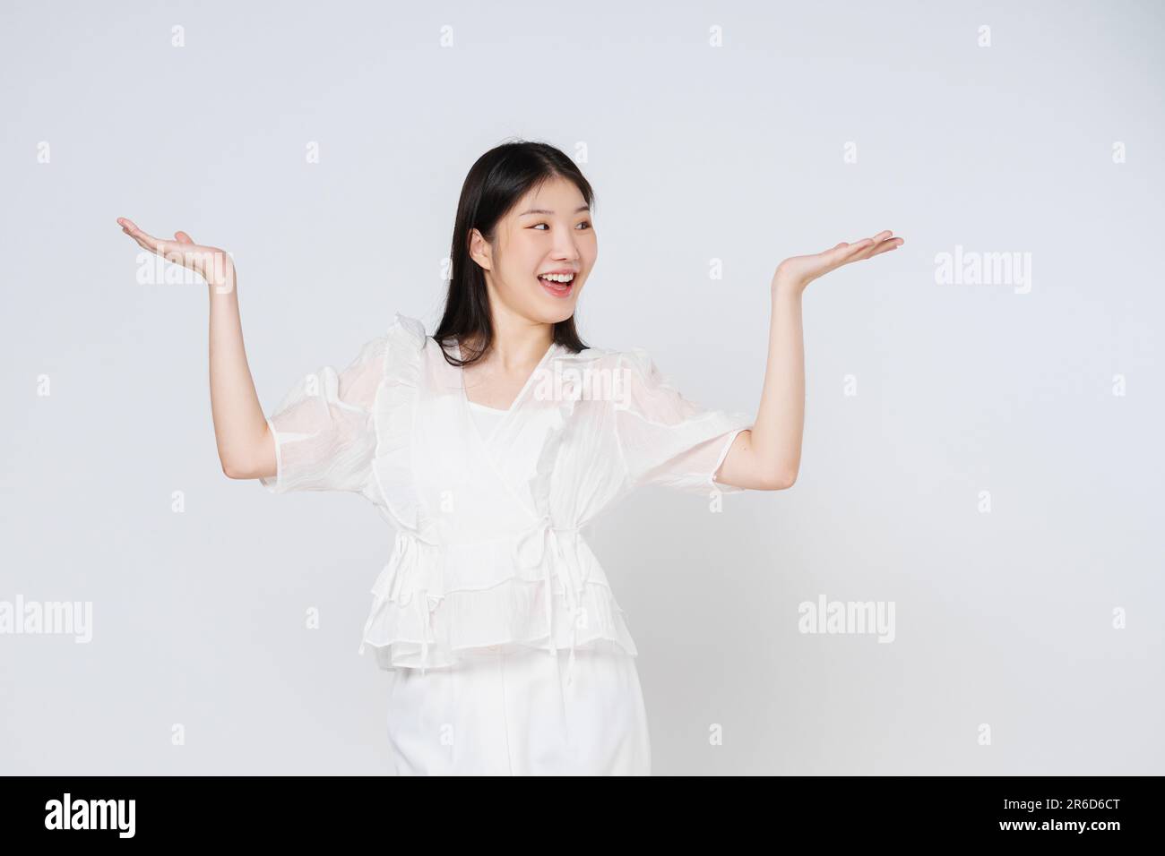 Happy young woman presenting or showing open hand palm with copy space ...