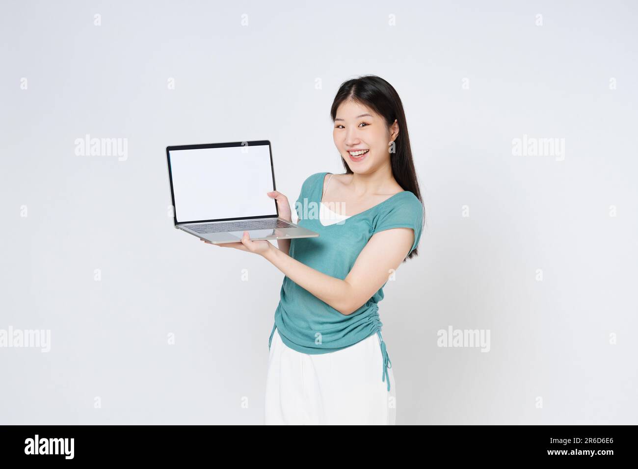 Smiling woman showing blank laptop computer screen isolated over white ...