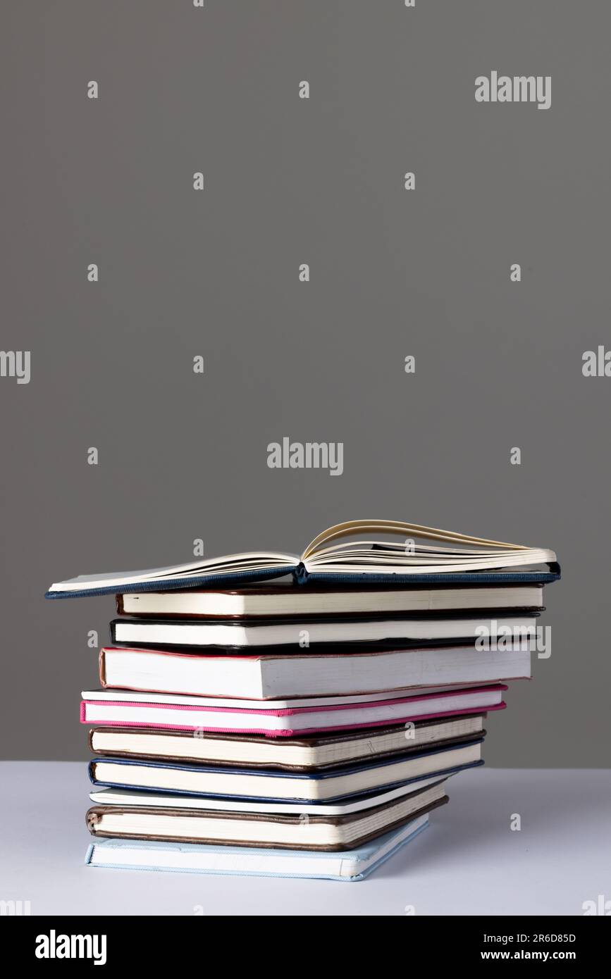 Close up of stack of books and notebooks with copy space on grey ...