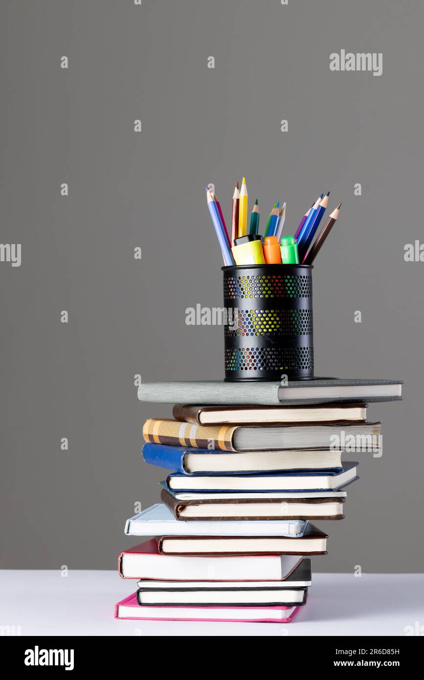 Stack of books and notebooks with pencil container on top and copy ...