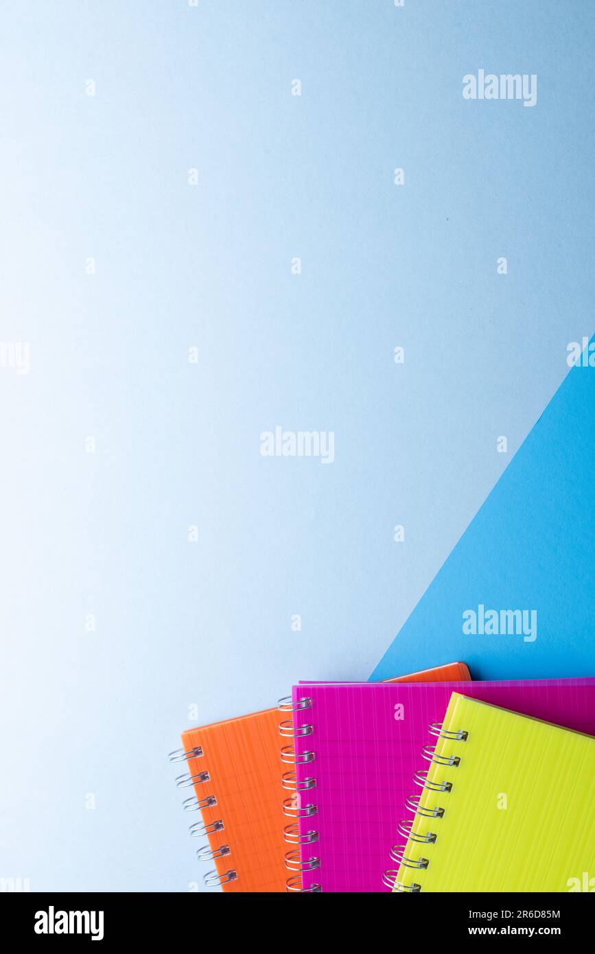 Three notebooks with binding and copy space on blue background. Reading ...