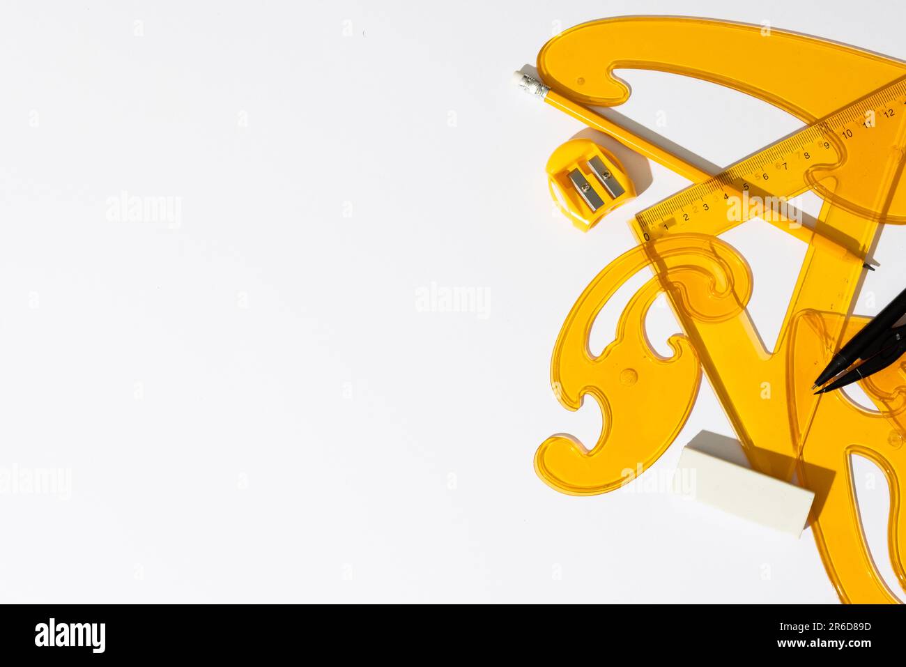 Close up of yellow rulers, compass and sharpener on white background ...