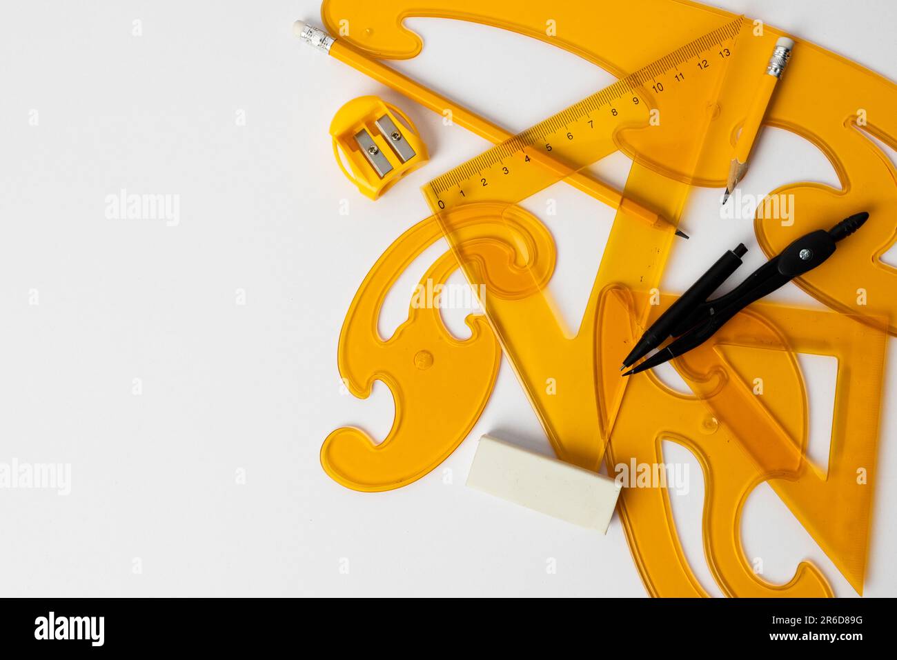 Close up of yellow rulers, compass and sharpener on white background ...