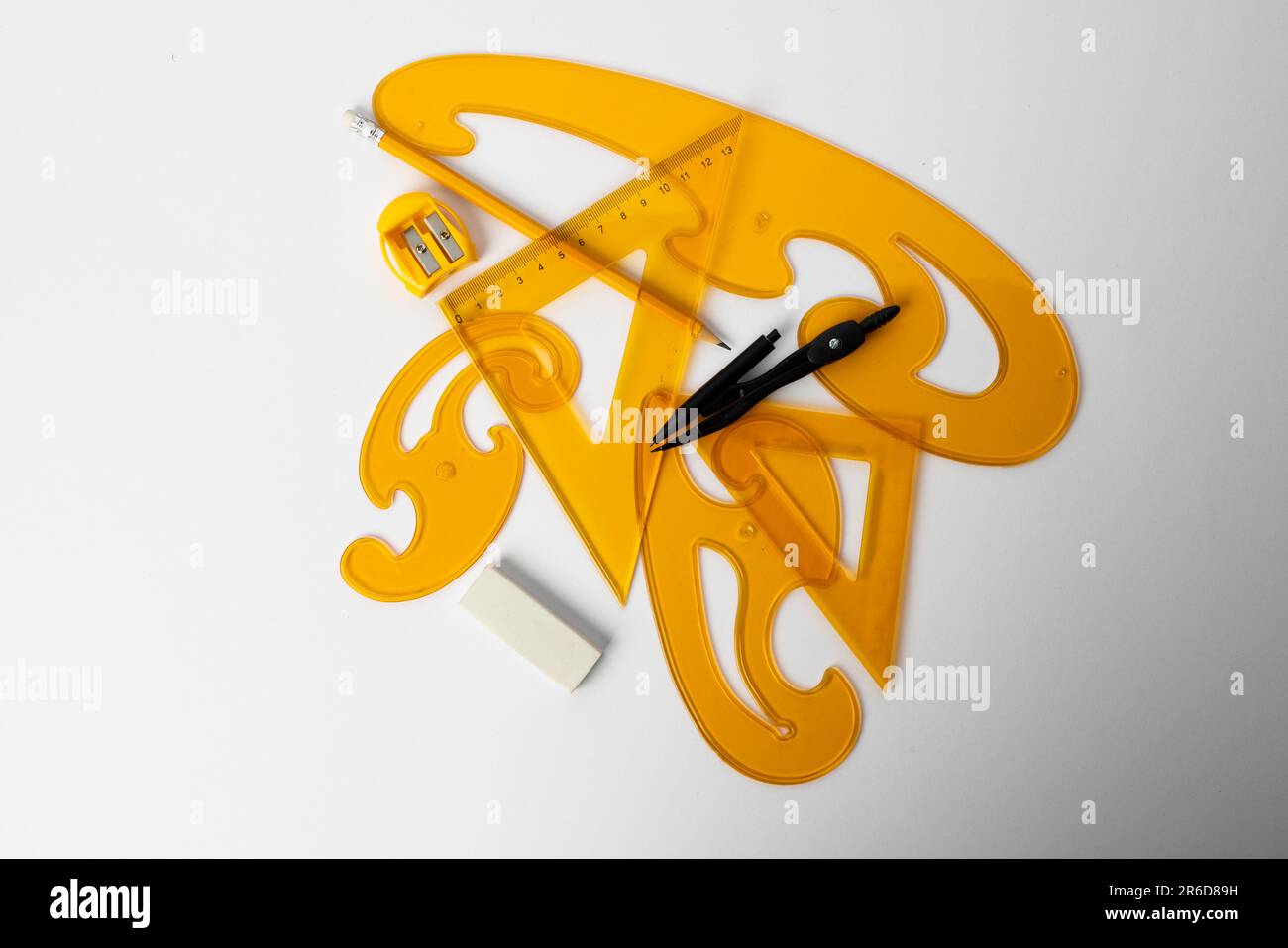 Close up of yellow rulers, compass and sharpener on white background ...