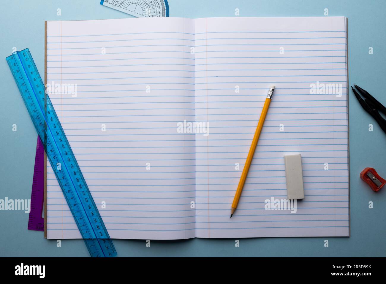 Close up of notebook with rulers and writing material on blue ...