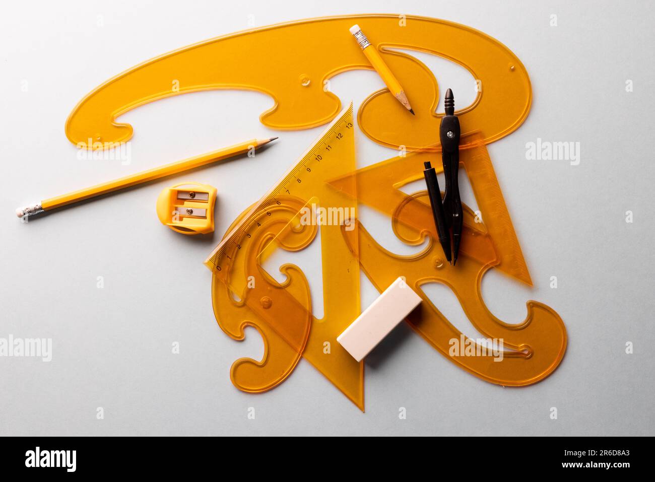 Close up of yellow rulers, compass and sharpener on white background ...