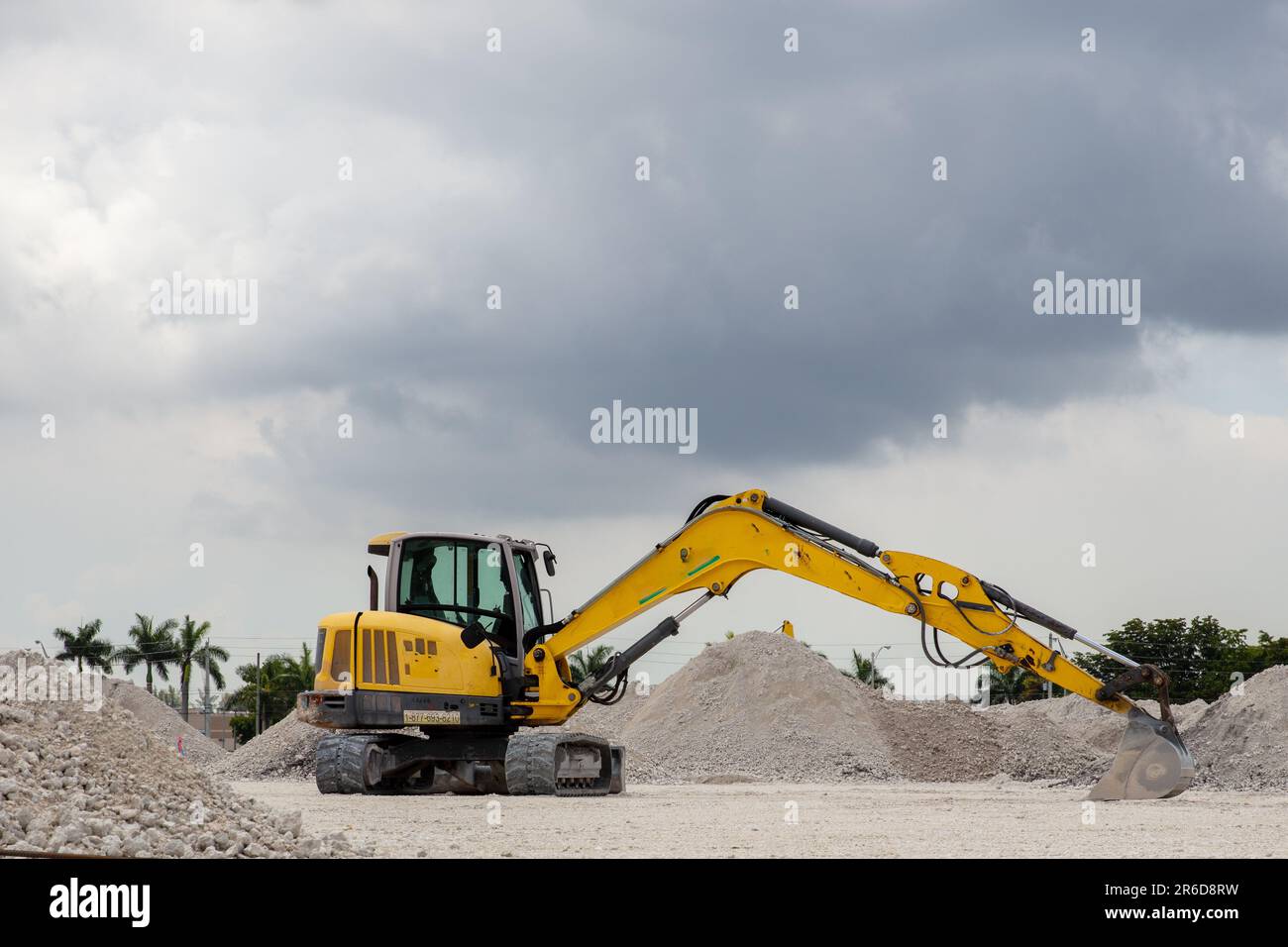 Yellow excavator with extended bucket at a landfill in South Florida ...