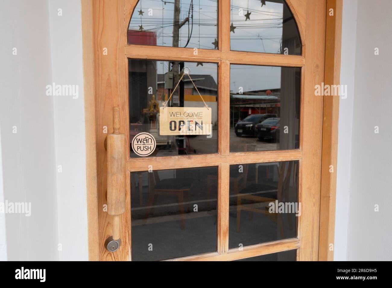 Wooden sign hangs welcome open coffee shop door Stock Photo - Alamy
