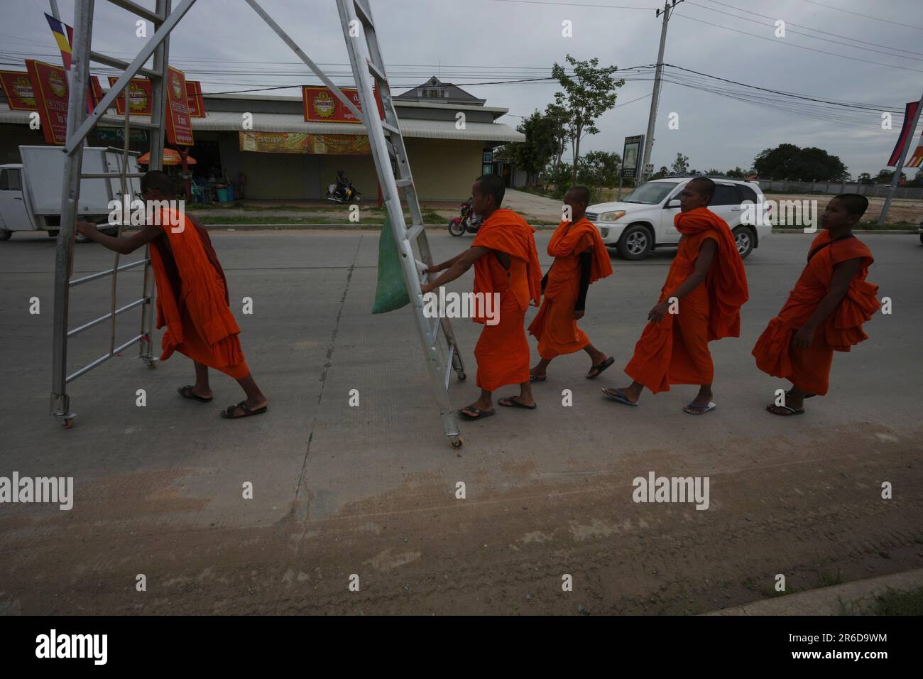 Cambodian Buddhist monks pull a ladder fore decorate Buddhist and their ...