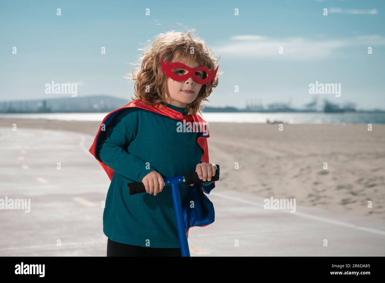 Child on scooter in park. Power kids, super hero child in a superhero ...