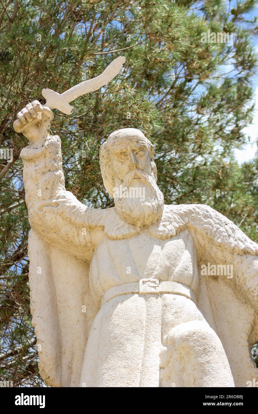 A statue depicting the prophet Elijah with his sword raised stands on ...