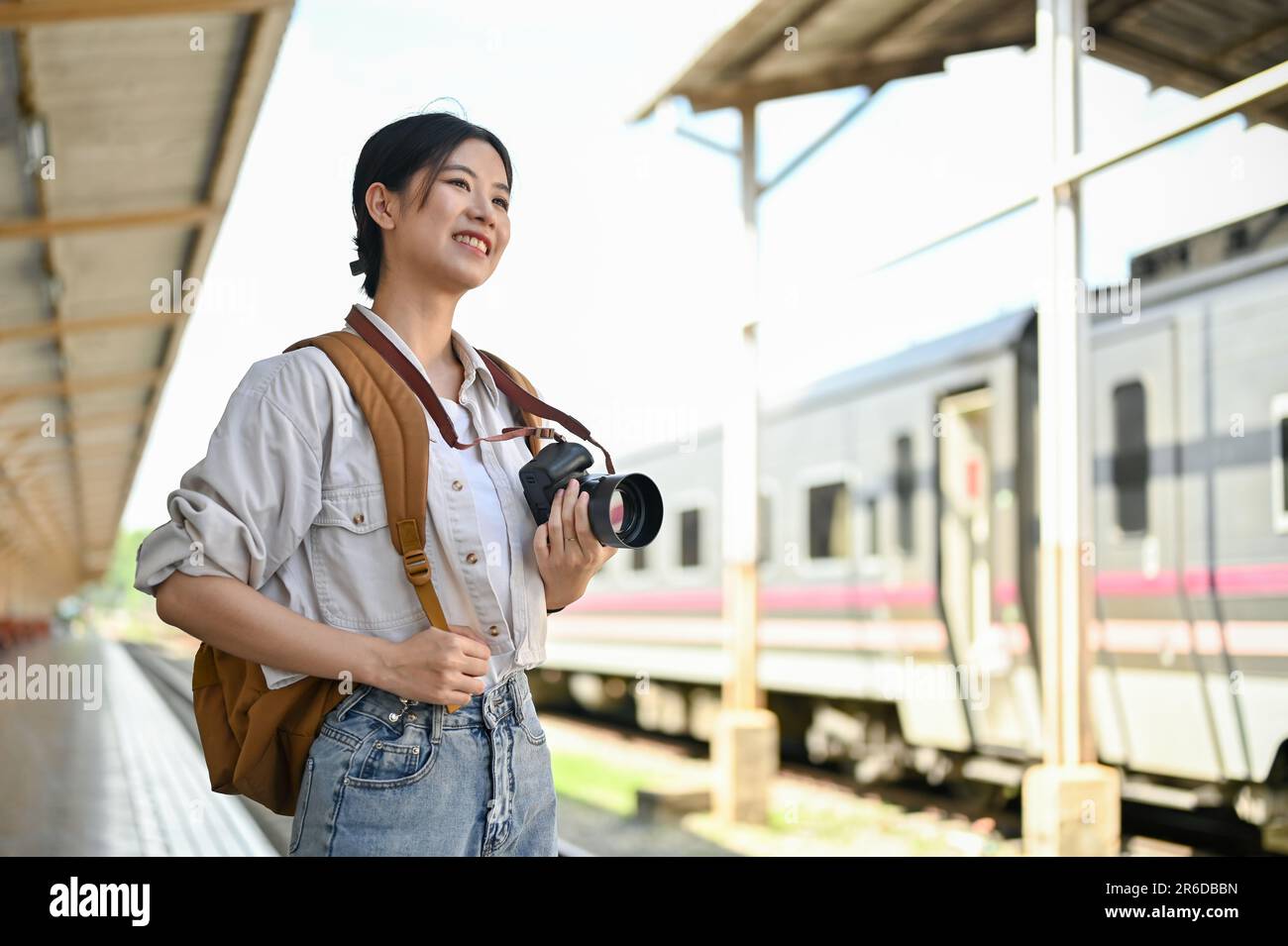 A beautiful and happy young Asian female traveler or backpacker with ...