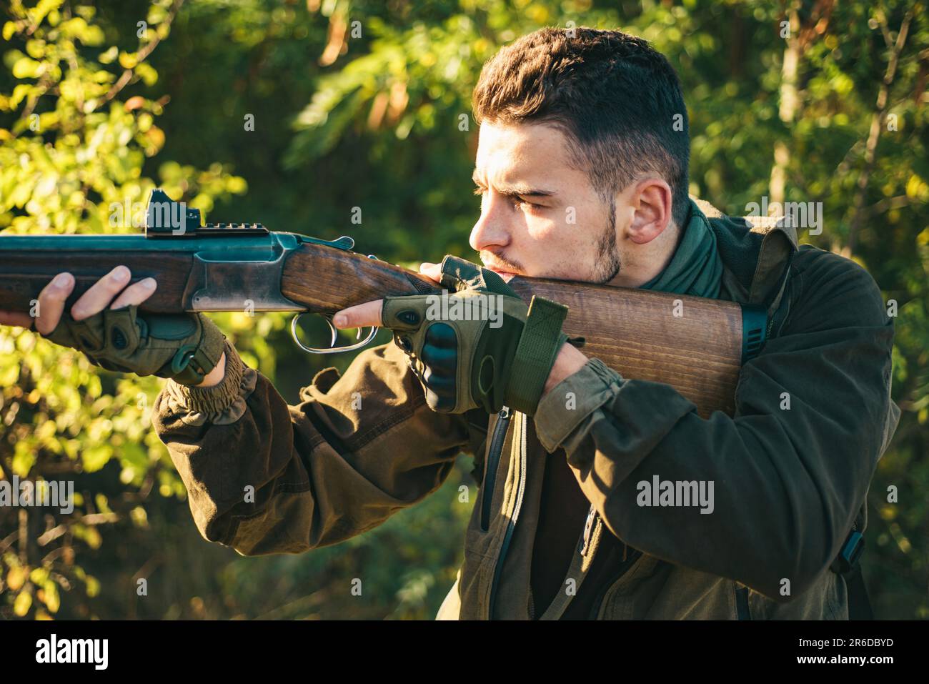 Hunter aiming rifle in forest. Hunter with shotgun gun on hunt. Hunting ...